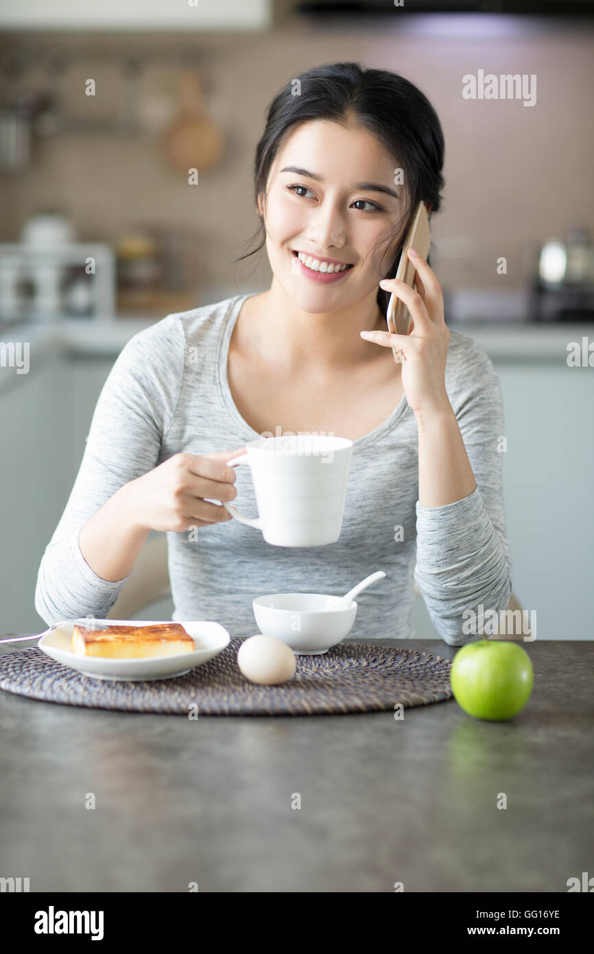 Young Chinese woman eating breakfast at home Stock Photo - Alamy