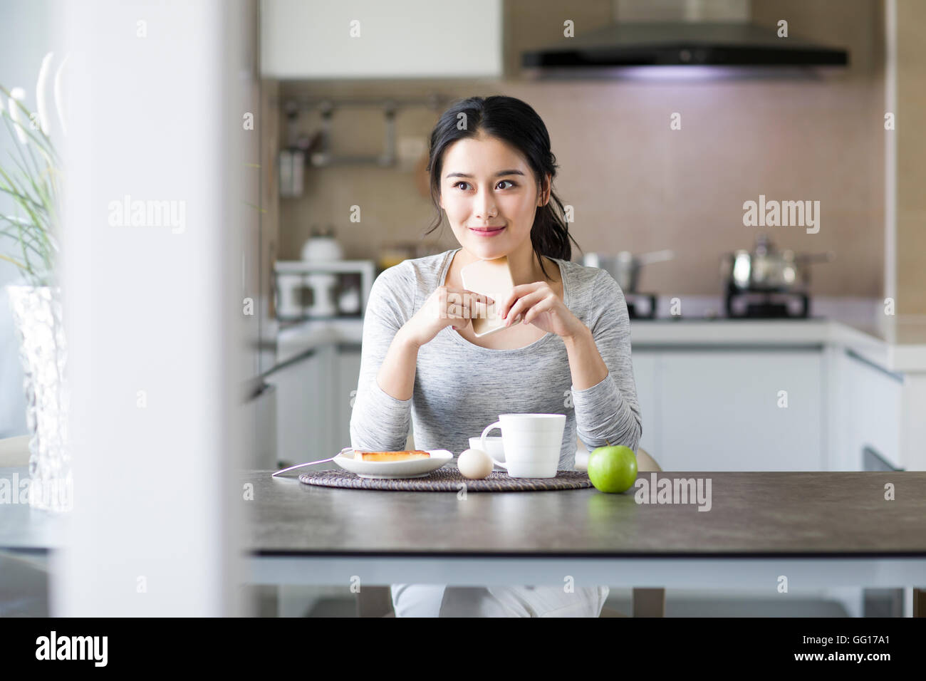 Young Chinese woman eating breakfast at home Stock Photo - Alamy