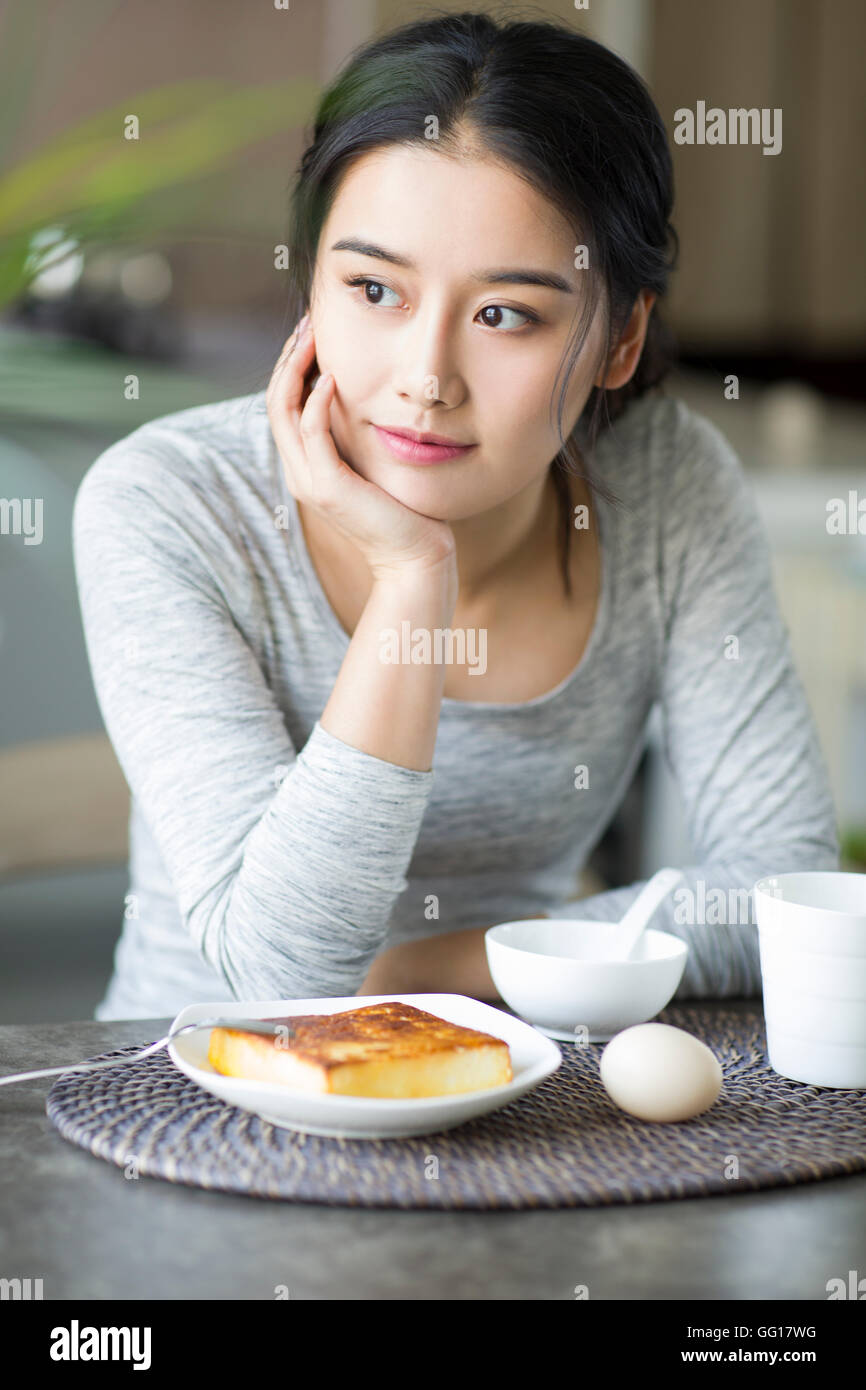 Young Chinese woman eating breakfast at home Stock Photo - Alamy