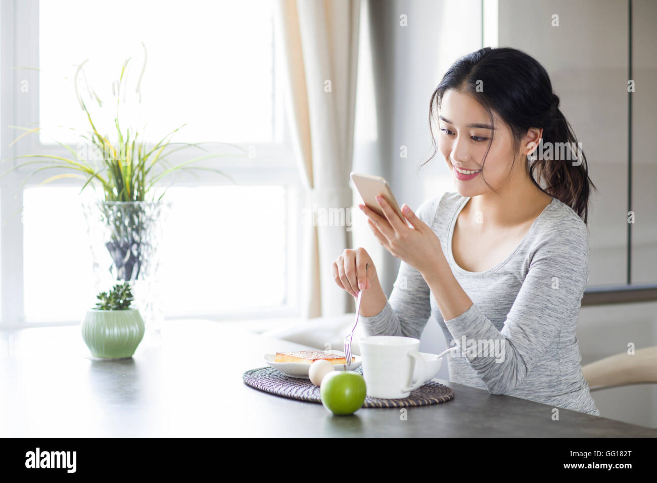 Young Chinese woman eating breakfast at home Stock Photo - Alamy
