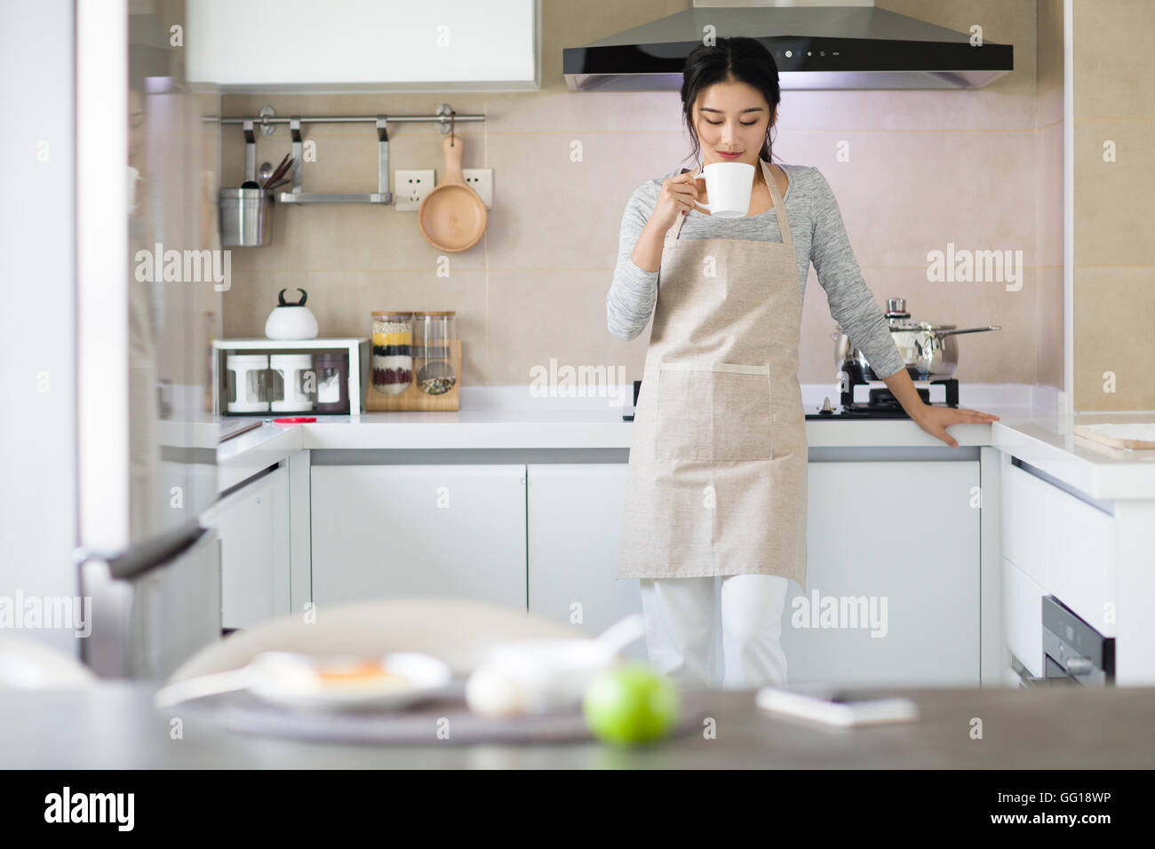 Young Chinese woman drinking coffee at home Stock Photo - Alamy