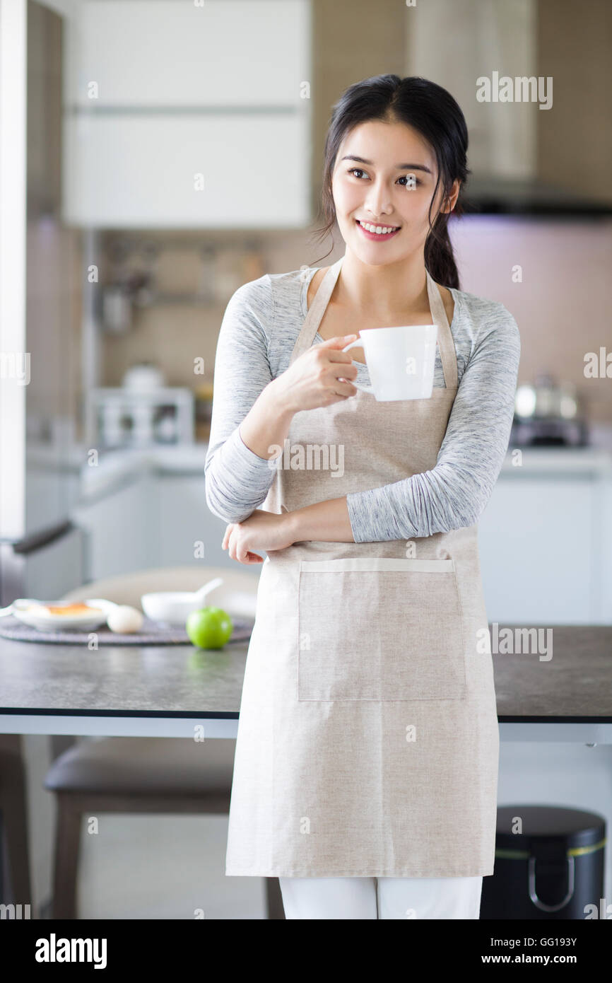Young Chinese woman drinking coffee at home Stock Photo - Alamy