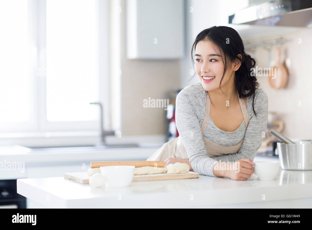 Young Chinese woman drinking coffee in kitchen Stock Photo - Alamy