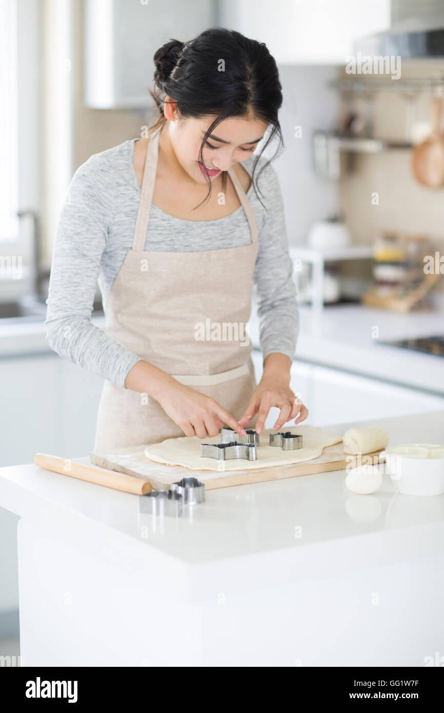 Young Chinese woman making cookies in kitchen Stock Photo - Alamy