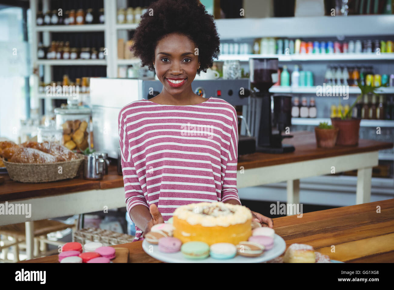 Smiling woman standing at counter in cafe Stock Photo - Alamy