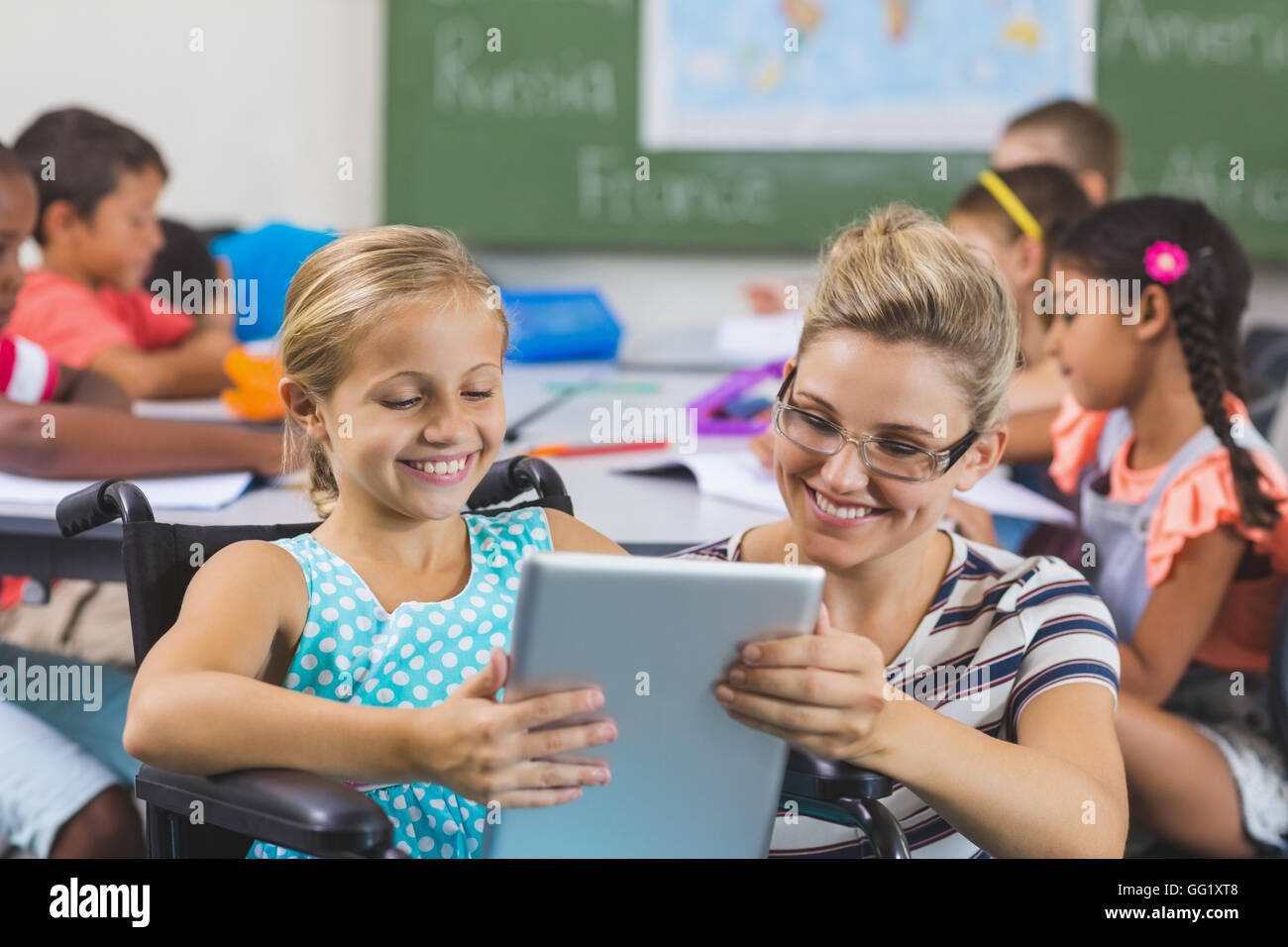 Schoolgirl and teacher using digital tablet in classroom Stock Photo ...