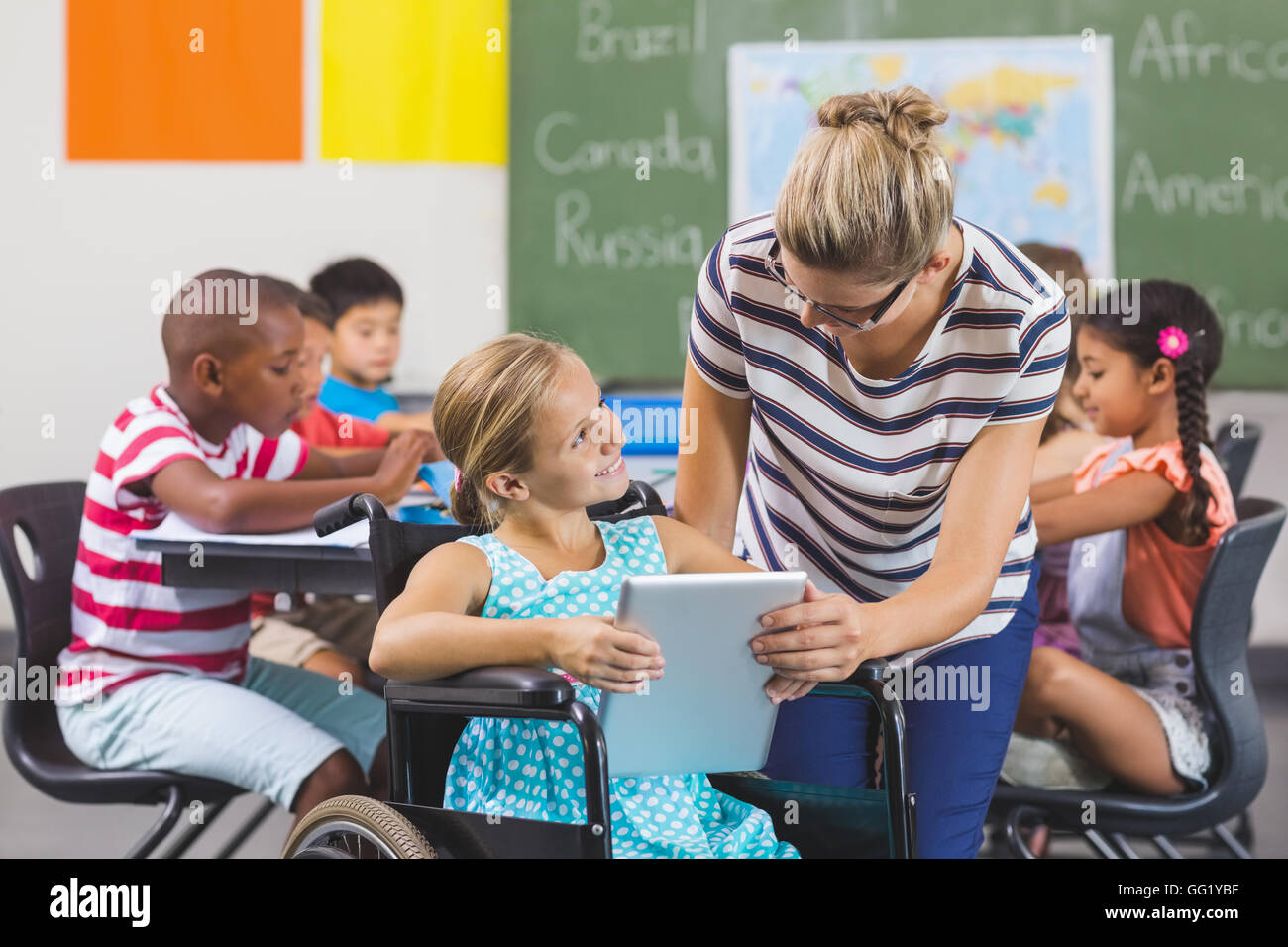 Schoolgirl and teacher using digital tablet in classroom Stock Photo ...