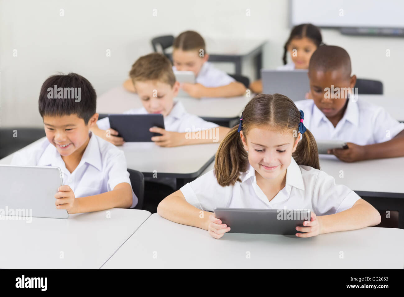 School kids using digital tablet in classroom Stock Photo - Alamy