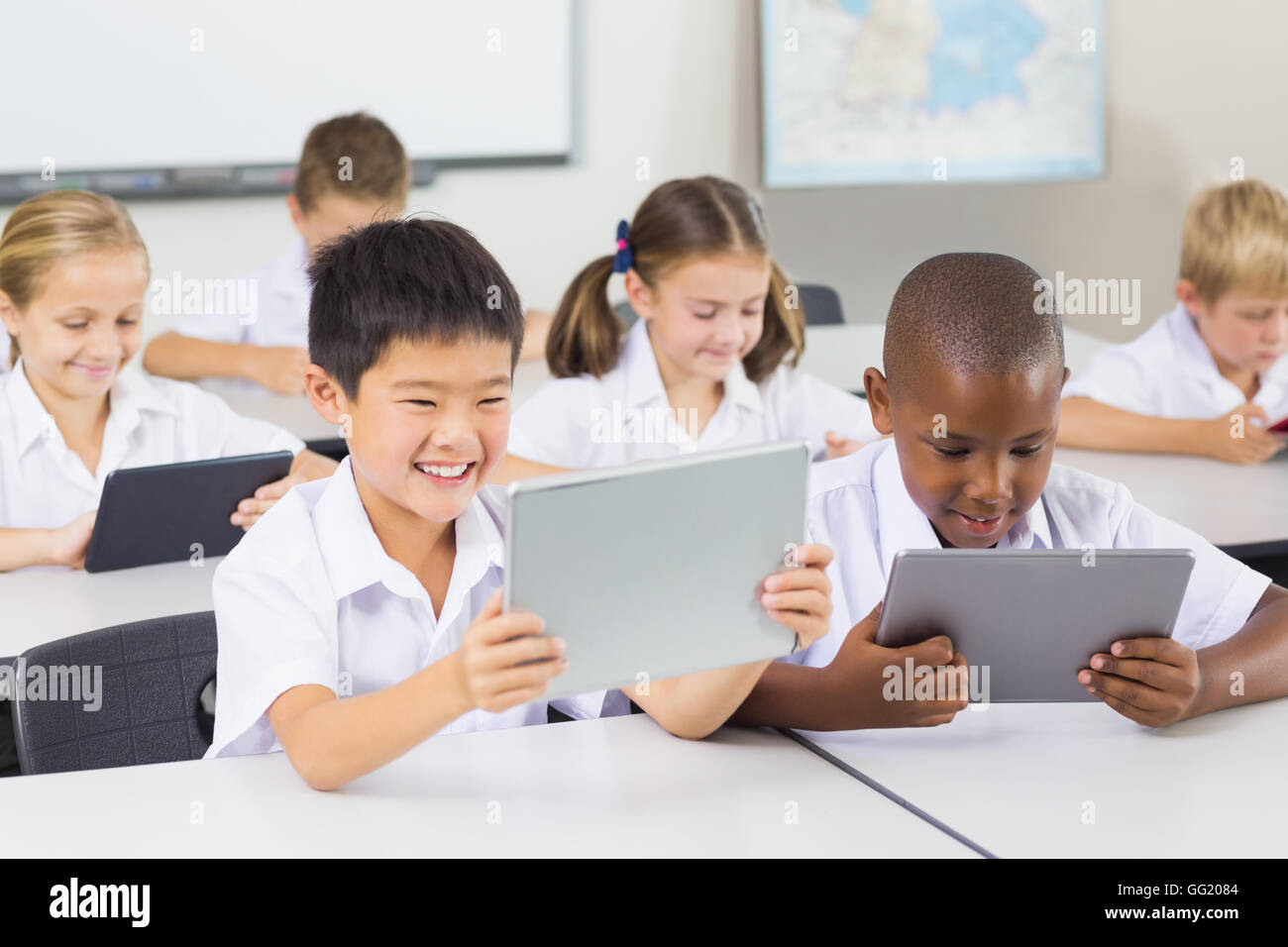 School kids using digital tablet in classroom Stock Photo - Alamy