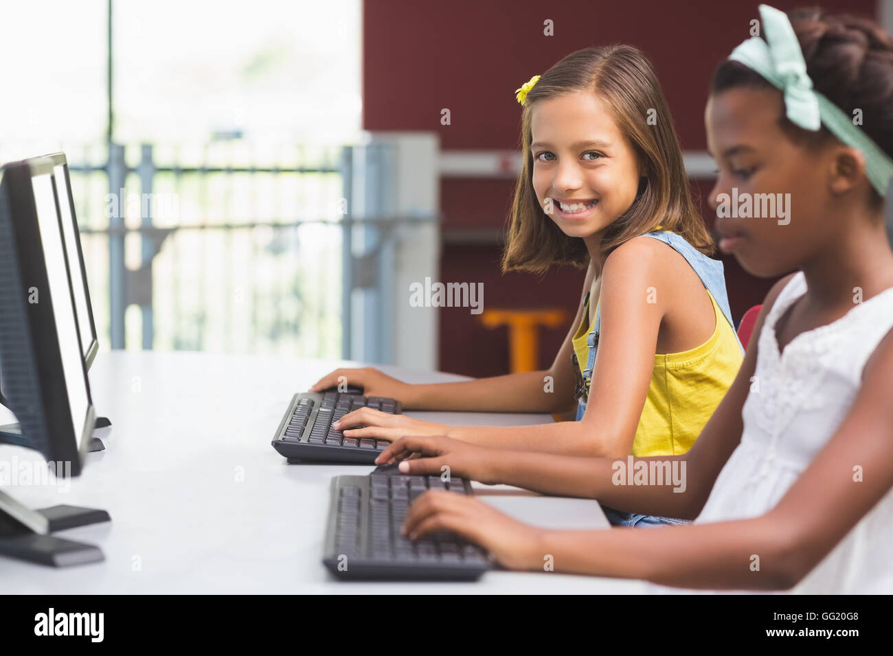 Schoolgirls using computer in classroom Stock Photo - Alamy