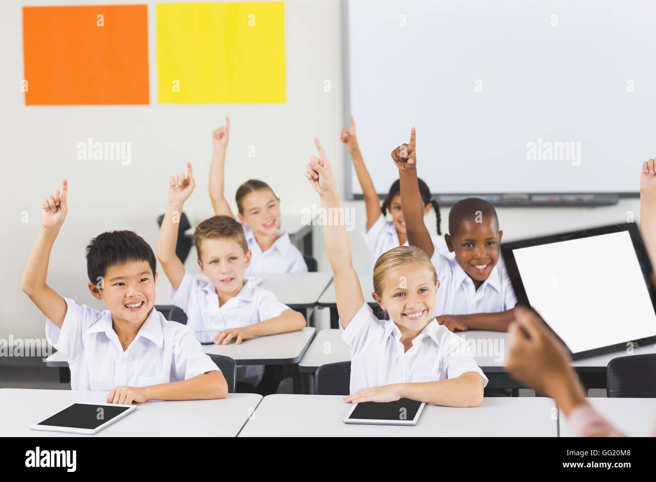 School kids raising hand in classroom Stock Photo - Alamy