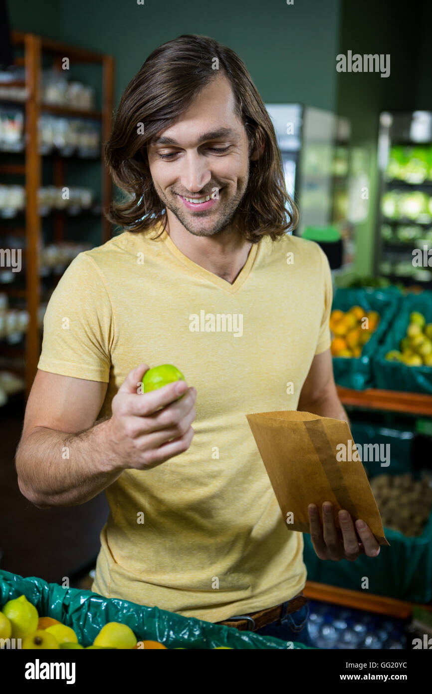 Man holding lemon in supermarket Stock Photo - Alamy