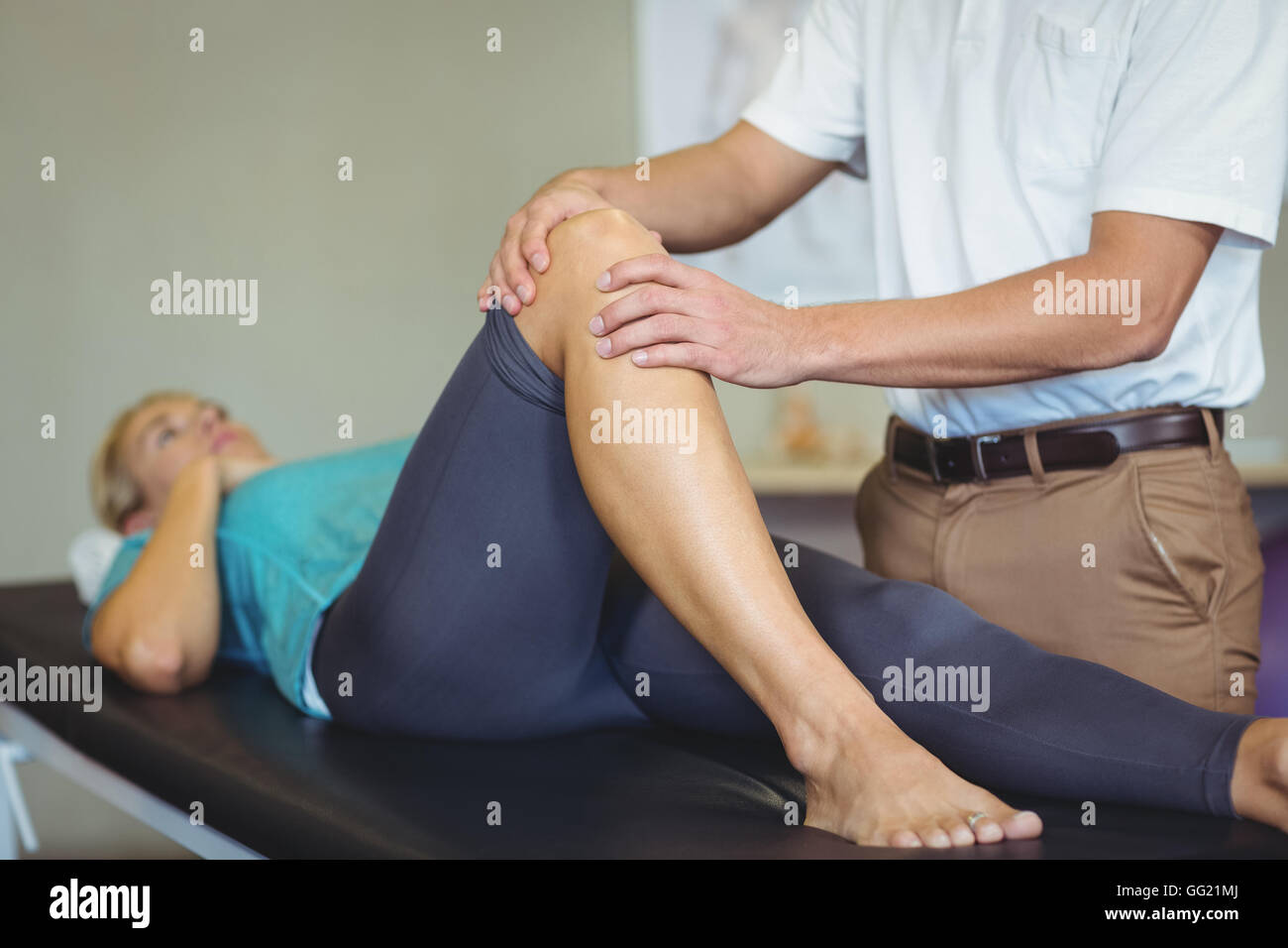 Male physiotherapist giving knee massage to female patient Stock Photo ...