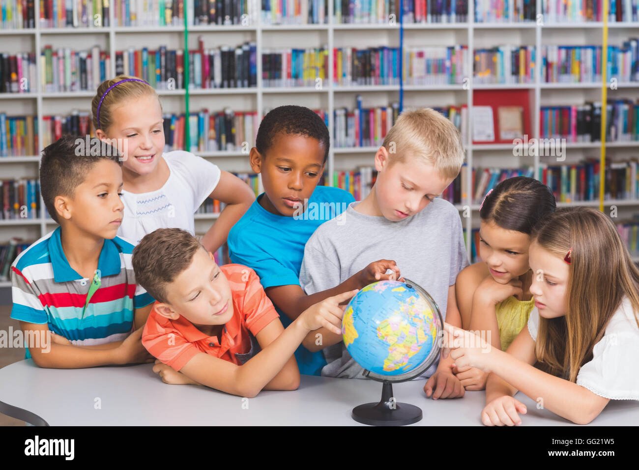 School kids looking at globe in library Stock Photo - Alamy