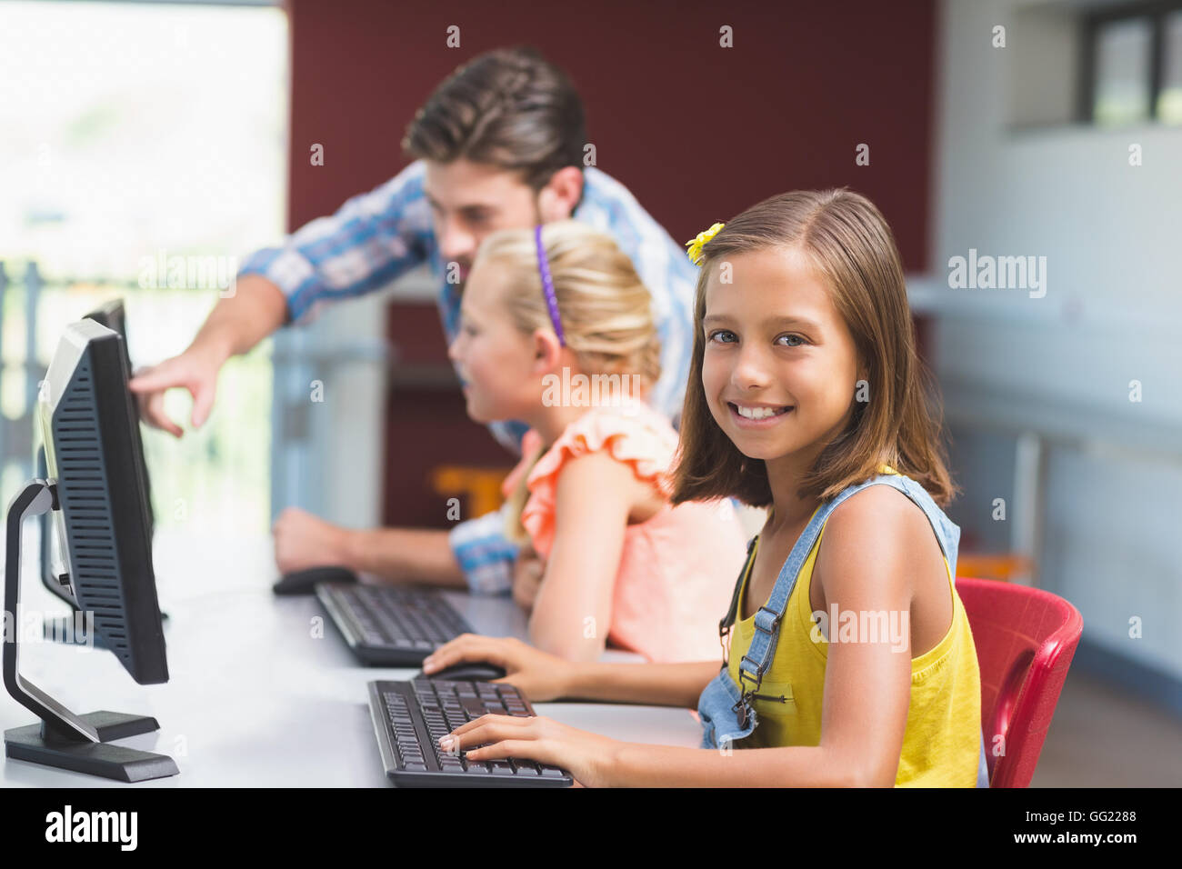 Schoolgirl using computer in classroom Stock Photo - Alamy