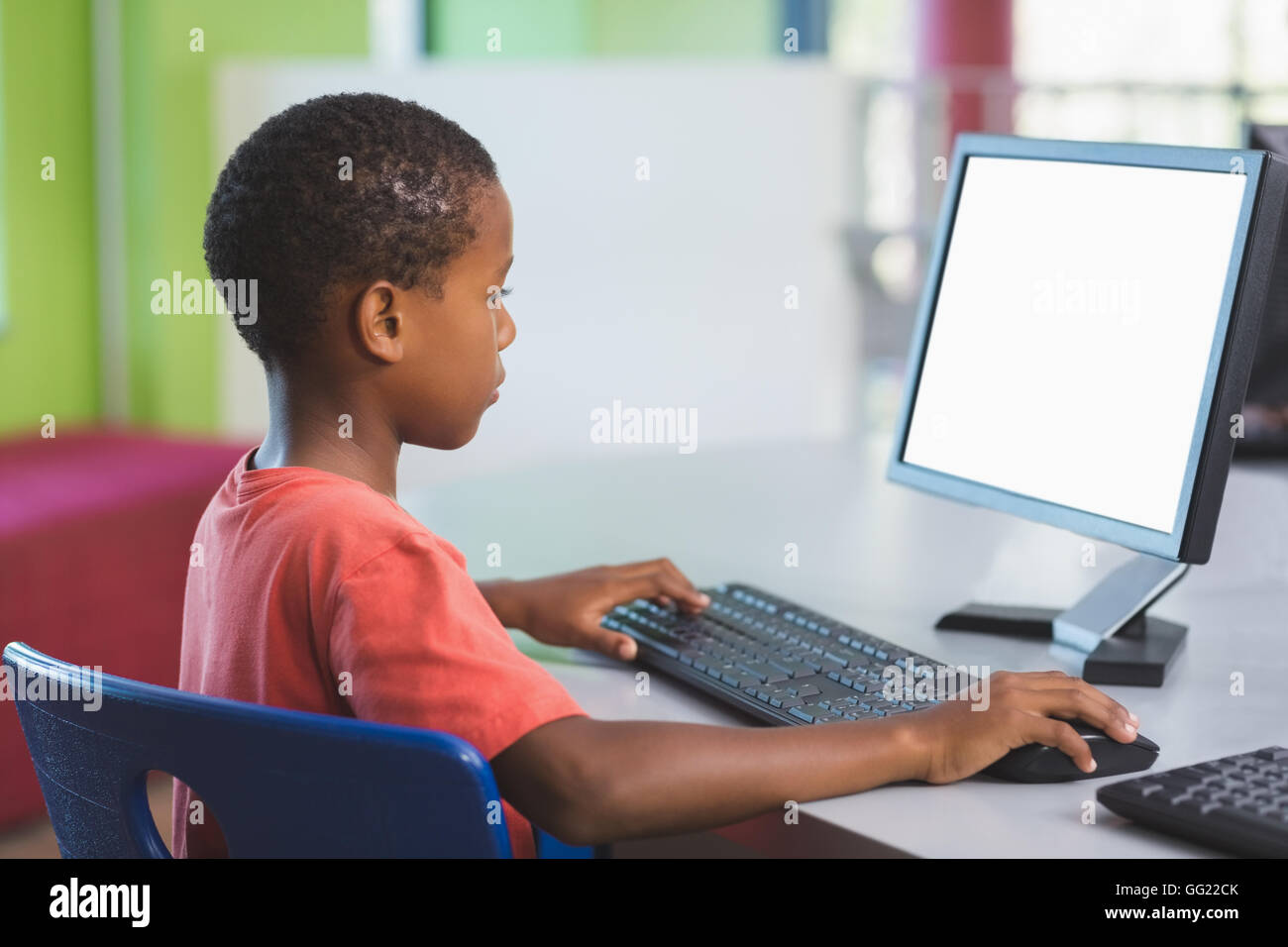 Schoolboy using computer in classroom Stock Photo - Alamy