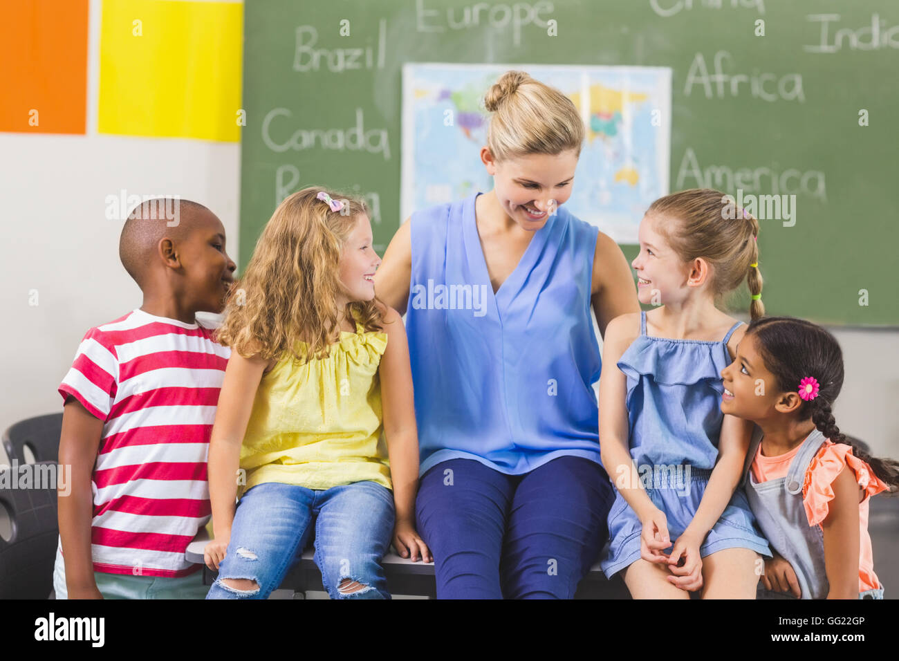 Teacher and kids having fun in classroom Stock Photo - Alamy