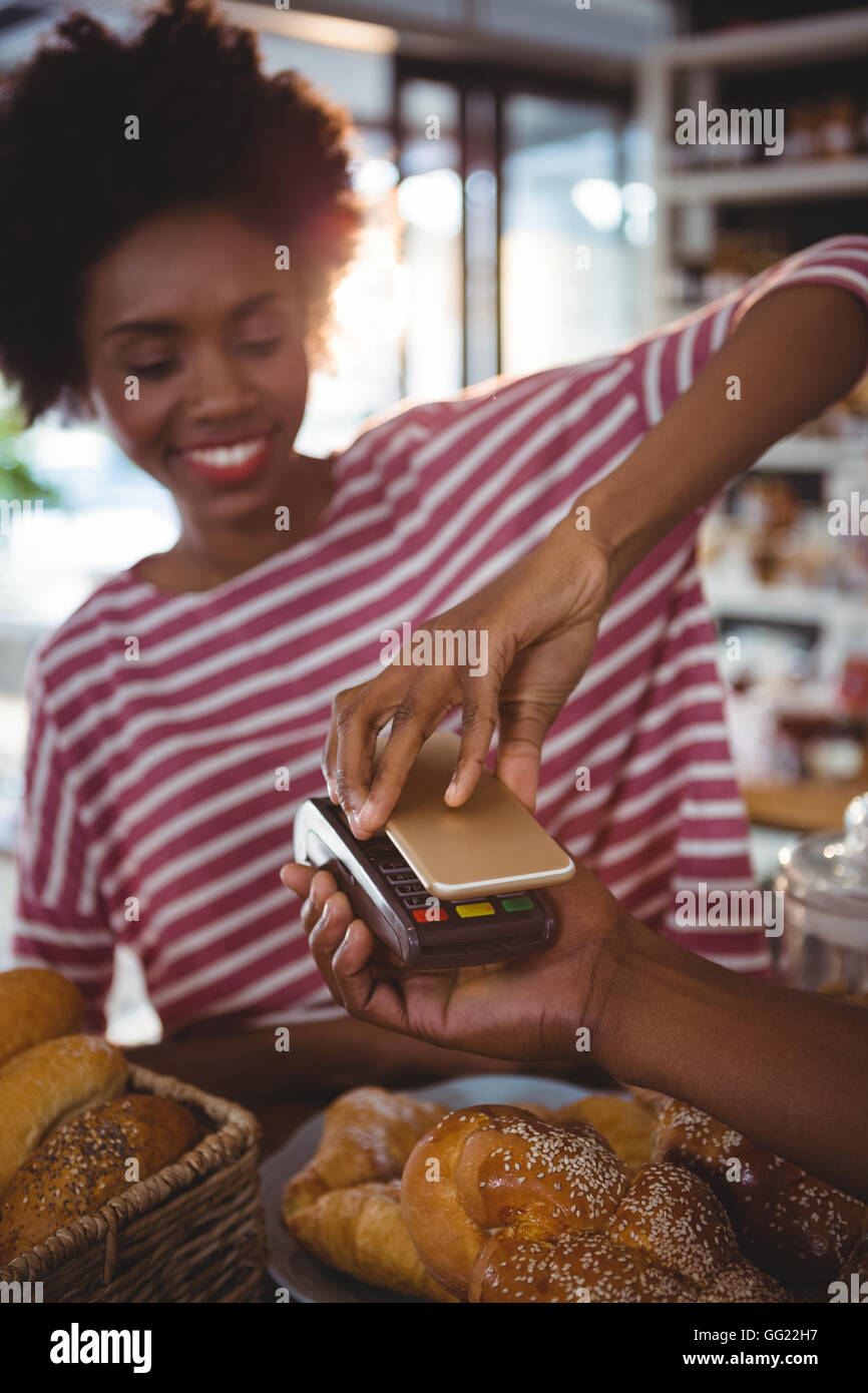 Woman paying bill through smartphone using nfc technology Stock Photo ...