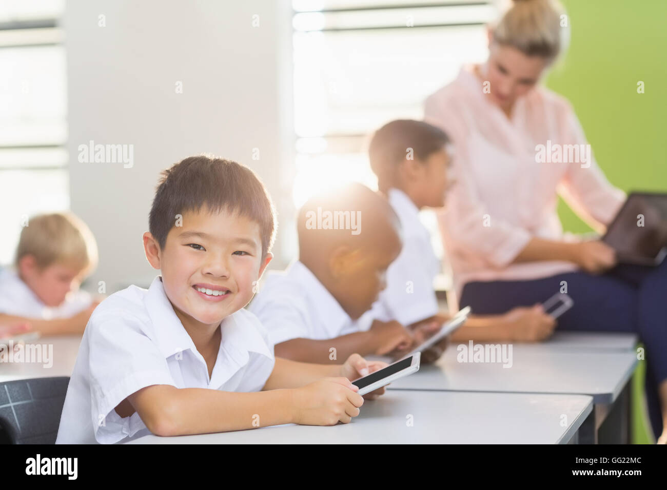 School kids using mobile phone in classroom Stock Photo - Alamy