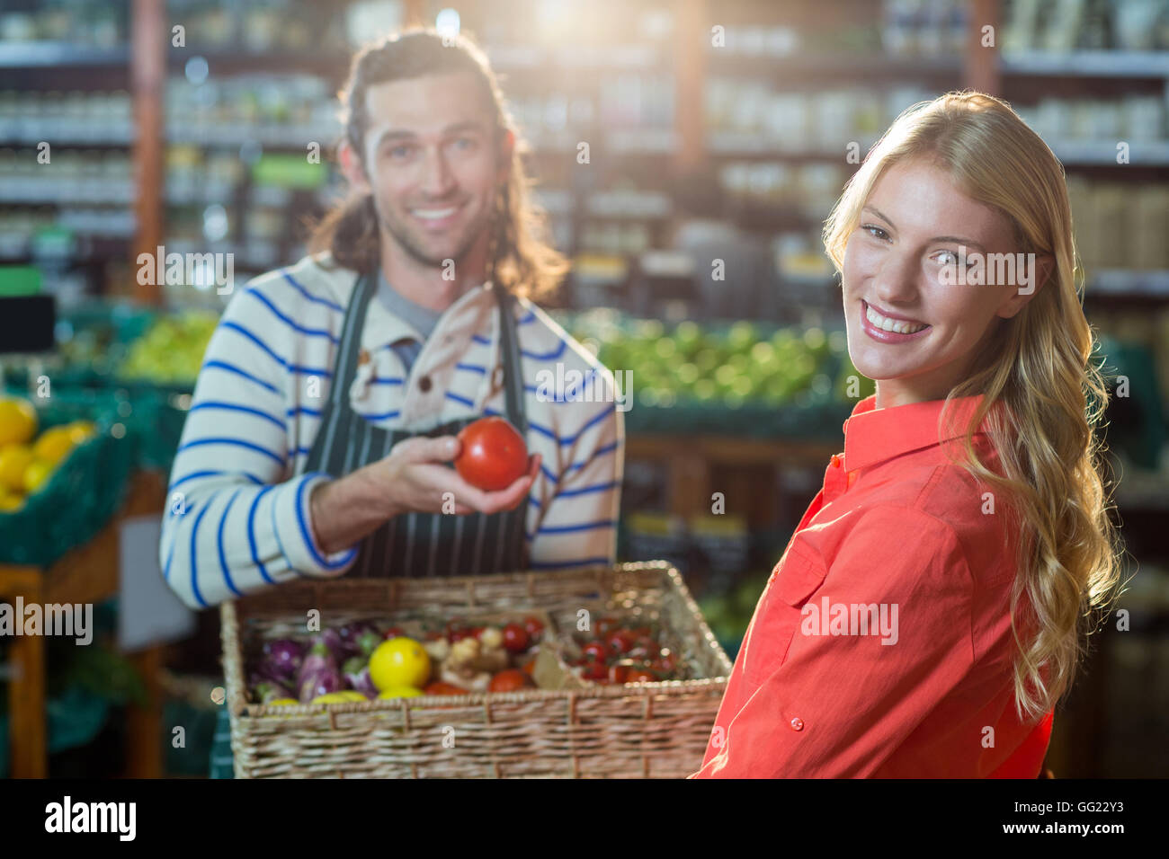 Male staff assisting woman in selecting fresh vegetables Stock Photo ...