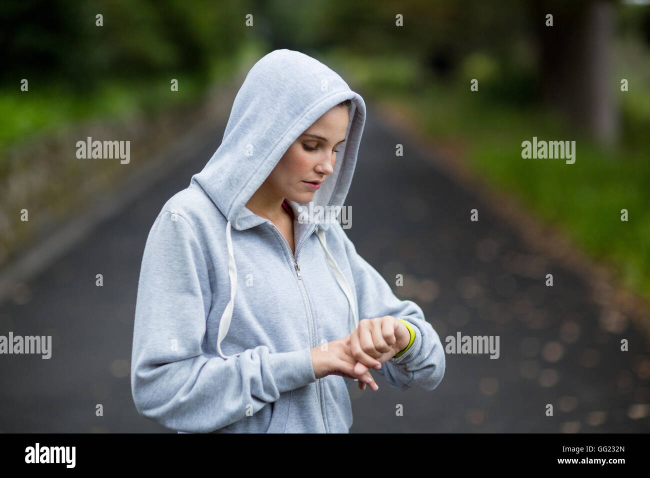 Beautiful woman checking time on wristwatch Stock Photo - Alamy