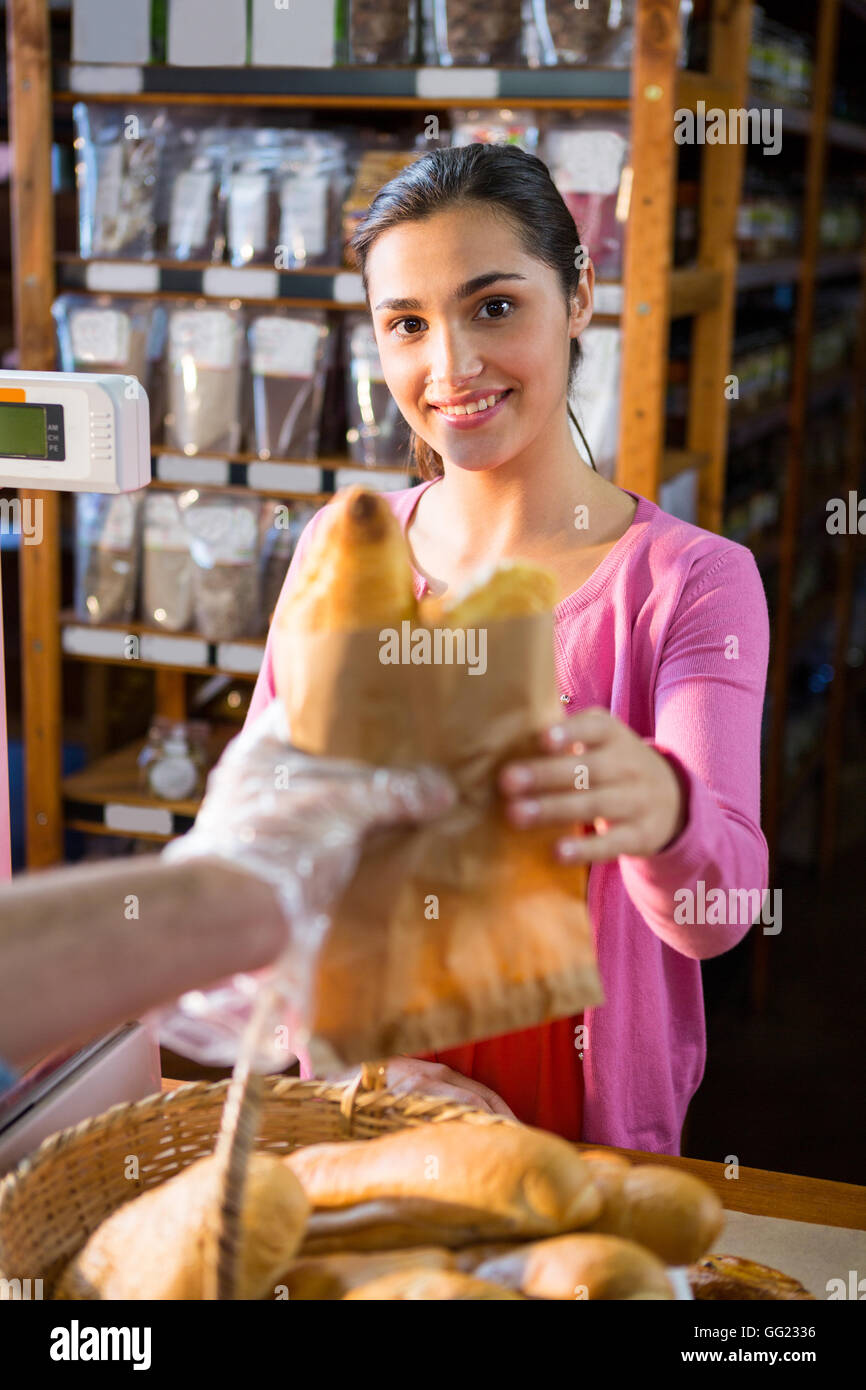 Staff giving packet bread to woman Stock Photo - Alamy