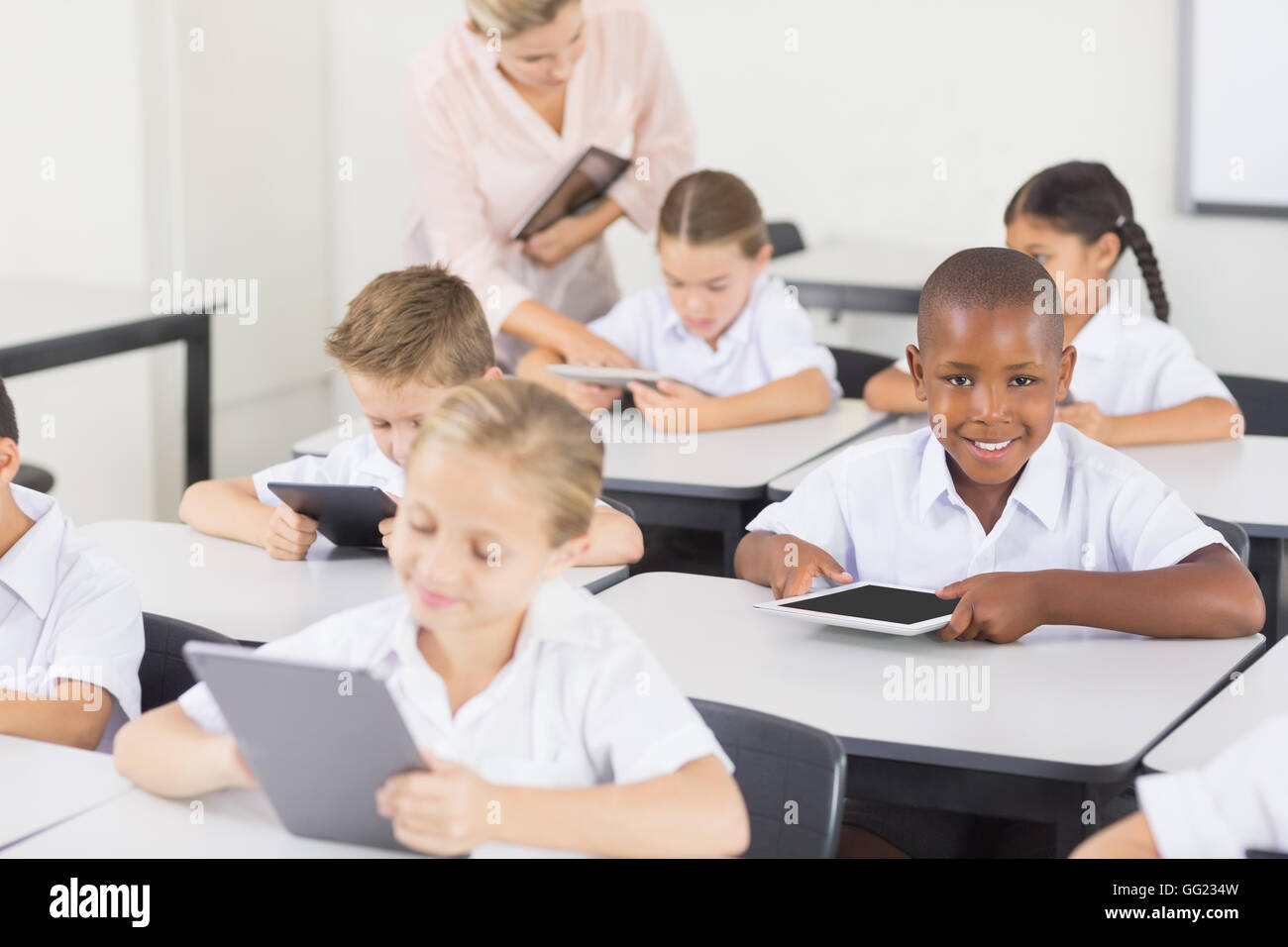 Students using digital tablet in classroom Stock Photo - Alamy