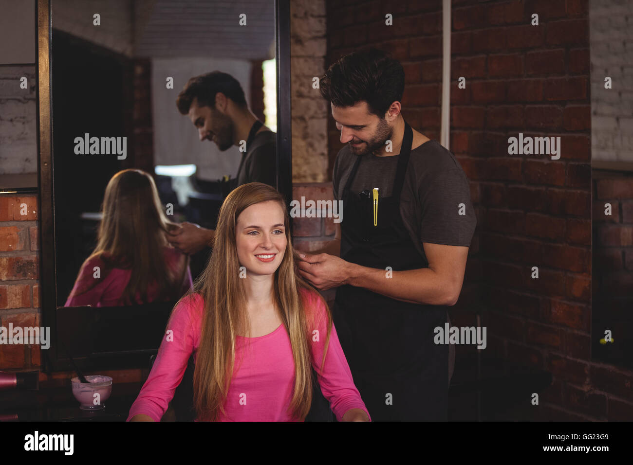 Handsome hair stylist with client Stock Photo - Alamy