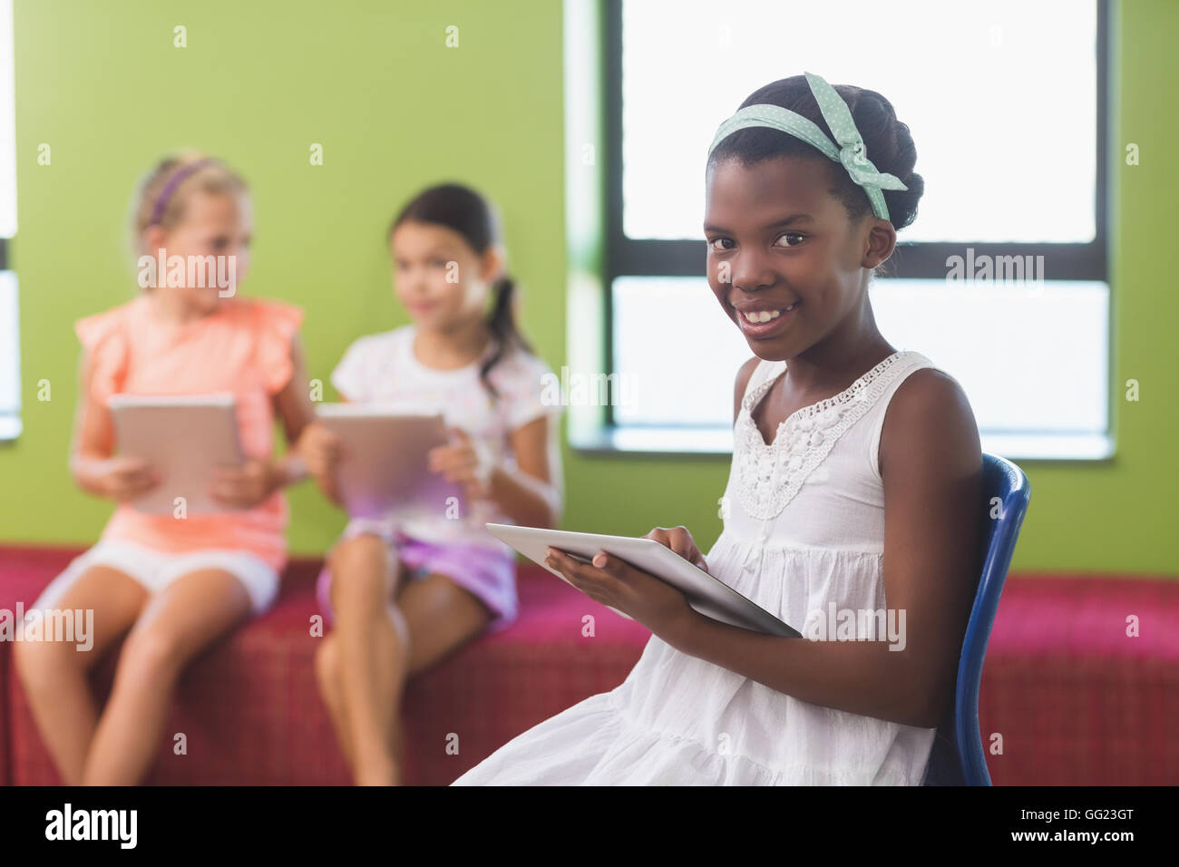 Schoolgirl using digital tablet in library Stock Photo - Alamy