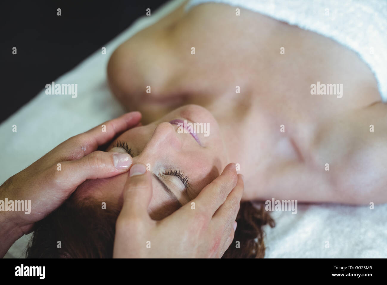 Woman receiving head massage from physiotherapist Stock Photo - Alamy