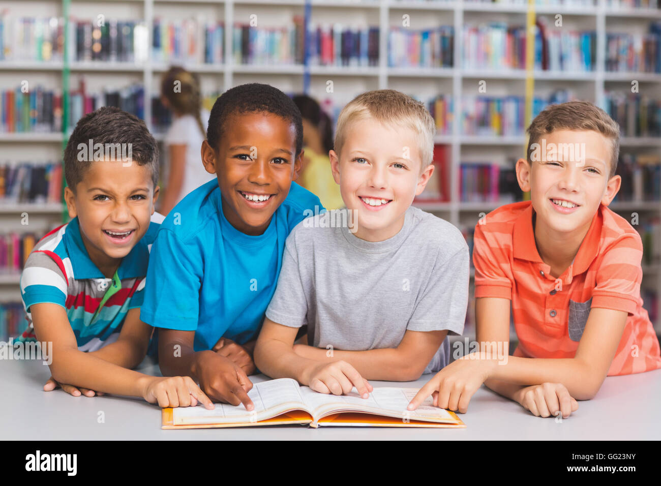 School kids reading book together in library Stock Photo - Alamy