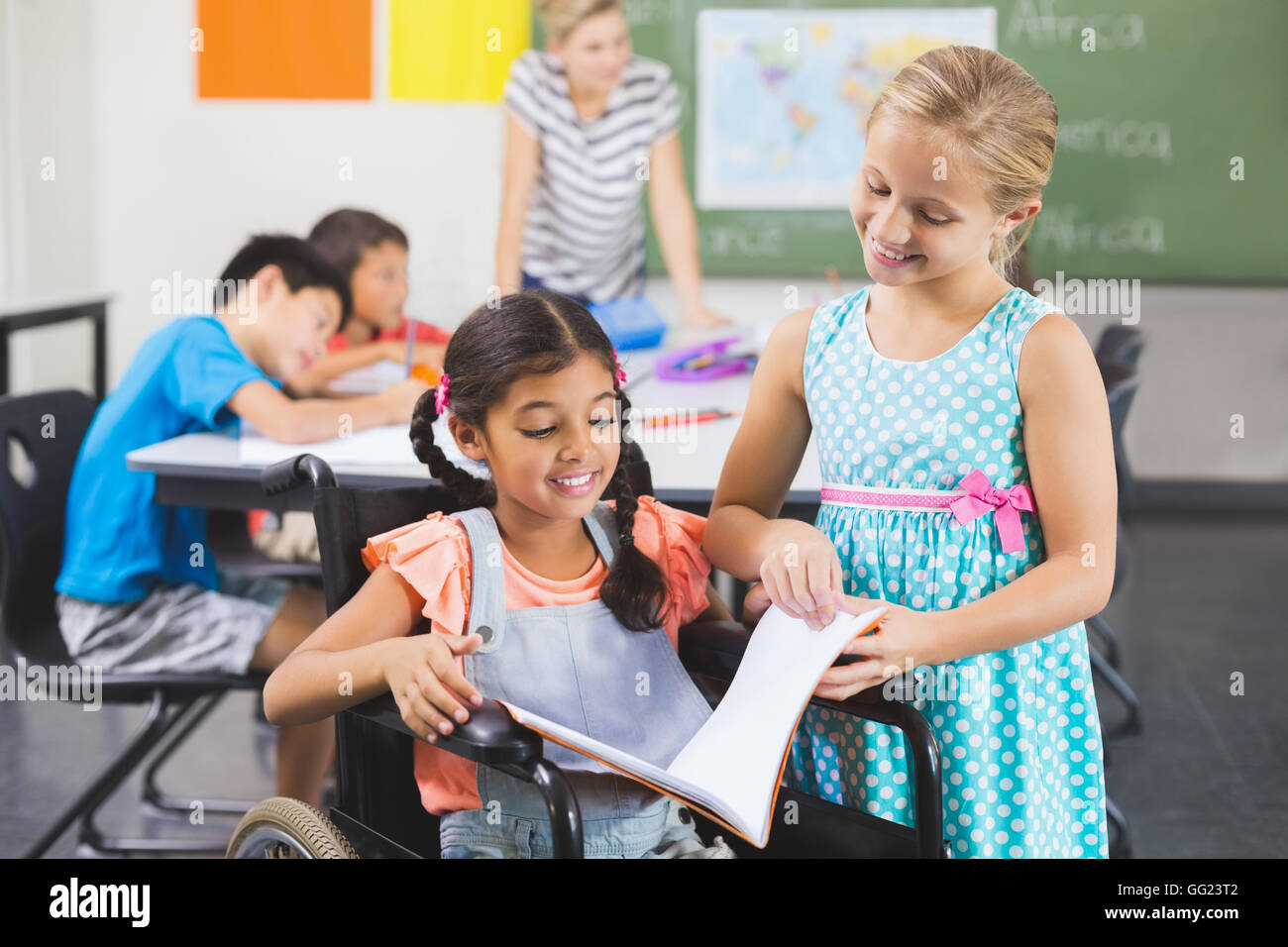 School kids reading book in classroom Stock Photo - Alamy