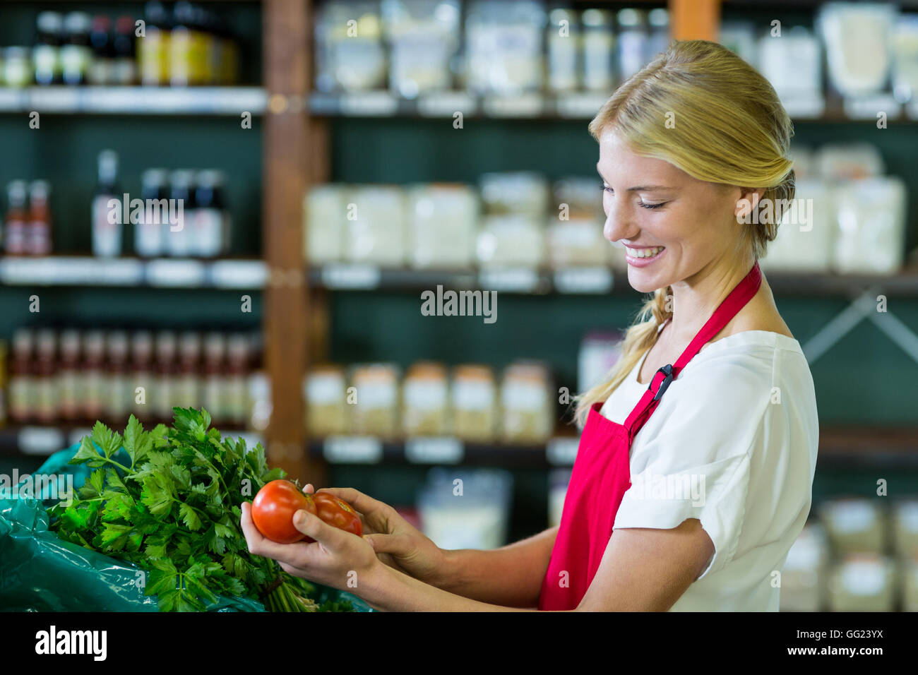 Female staff checking vegetables in organic section Stock Photo - Alamy