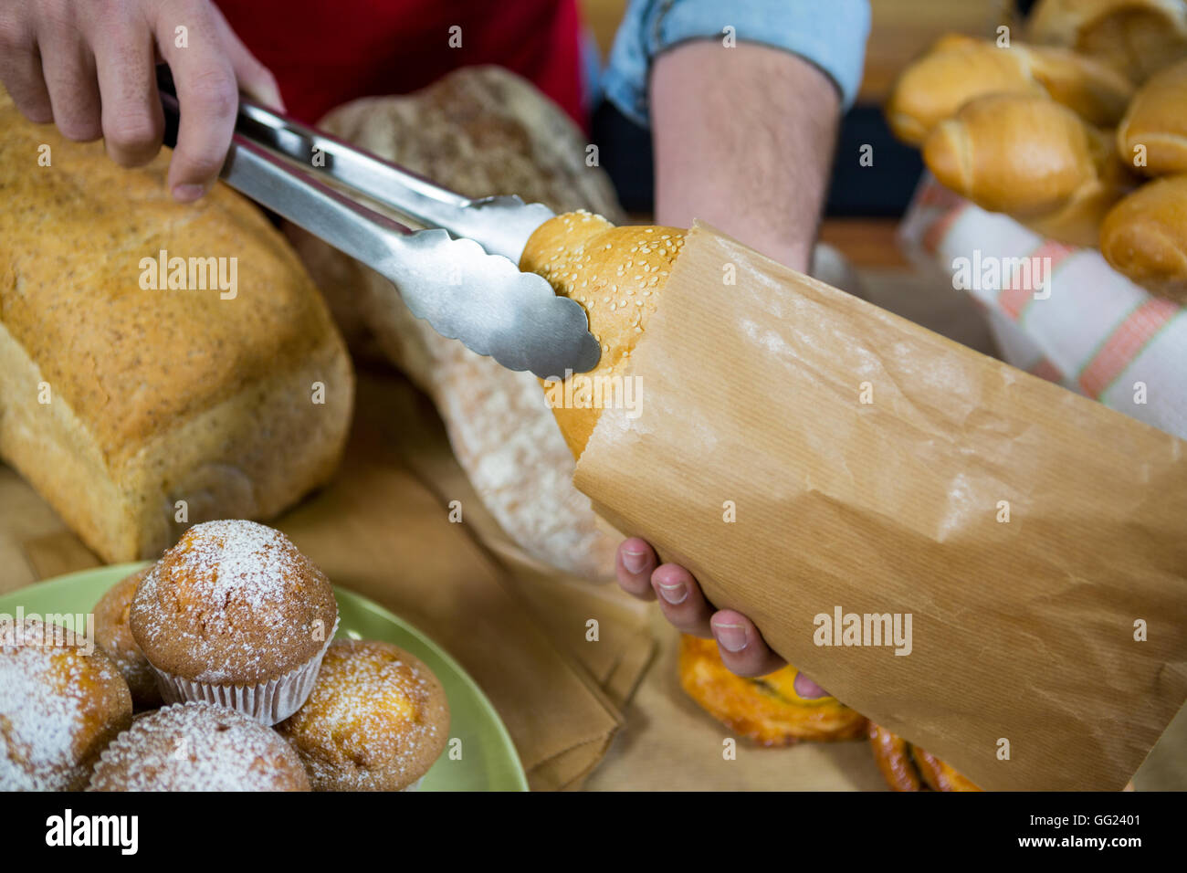 Staff packing a bread in paper bag Stock Photo - Alamy