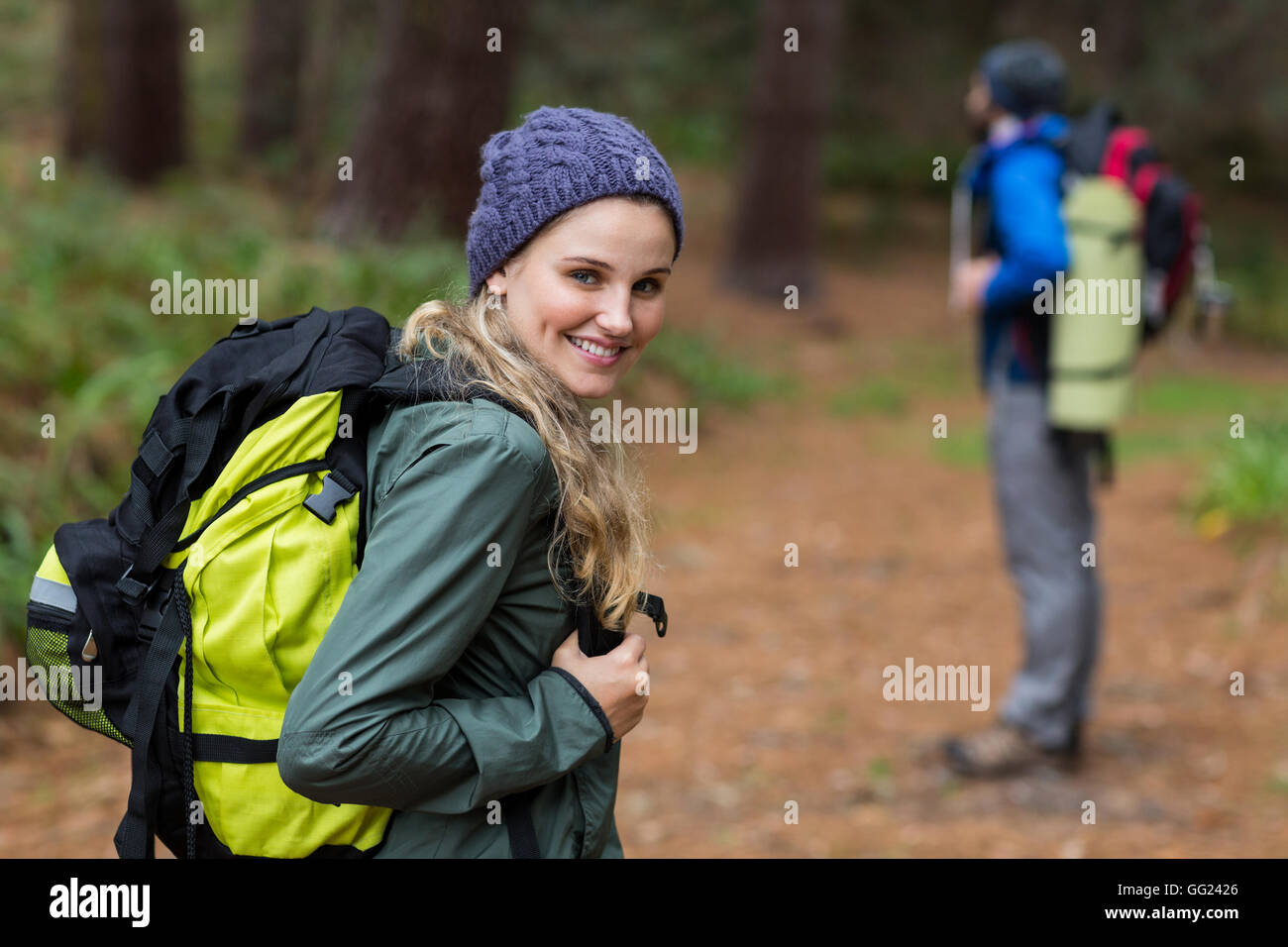 Woman looking back while hiking in forest Stock Photo - Alamy