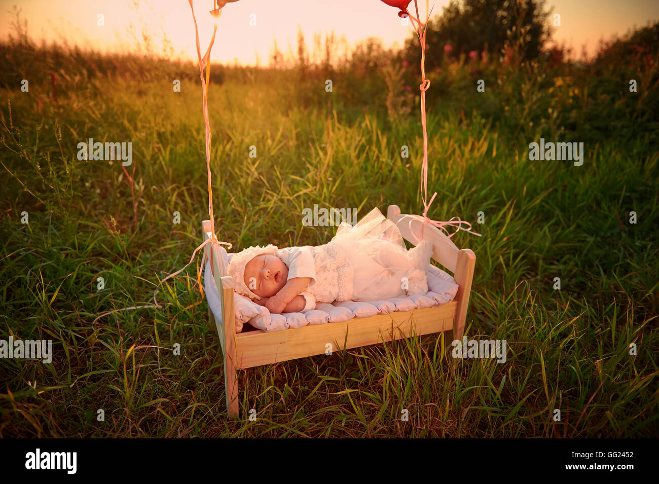 A tiny baby asleep in his crib in lace bonnet Stock Photo - Alamy