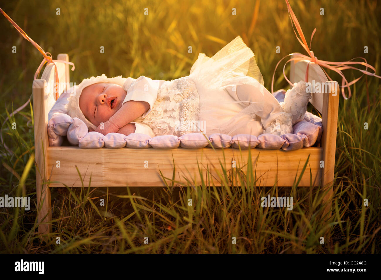 A tiny baby asleep in his crib in lace bonnet Stock Photo - Alamy