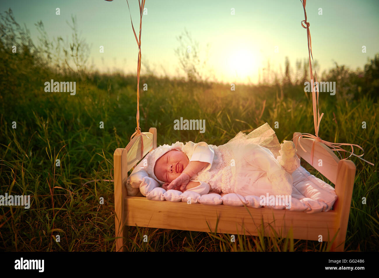 A tiny baby asleep in his crib in lace bonnet Stock Photo - Alamy