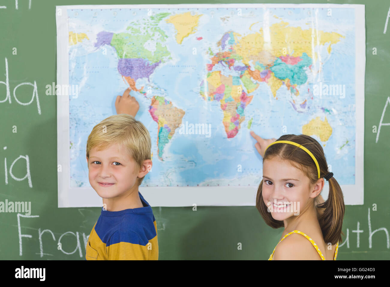 School kids pointing at map in classroom Stock Photo - Alamy