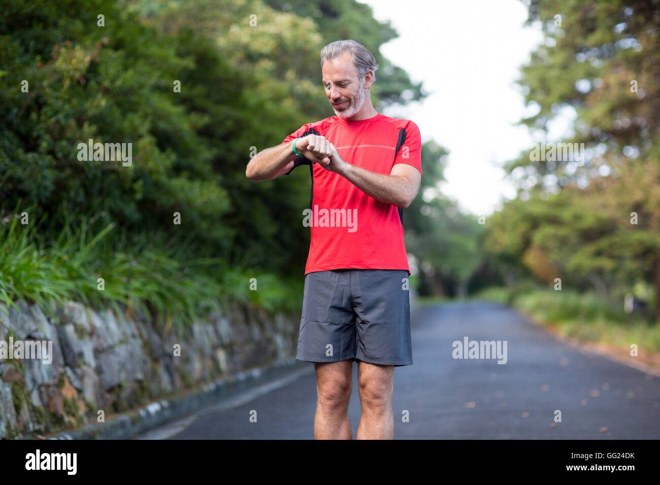 Athletic man checking time on wristwatch Stock Photo - Alamy