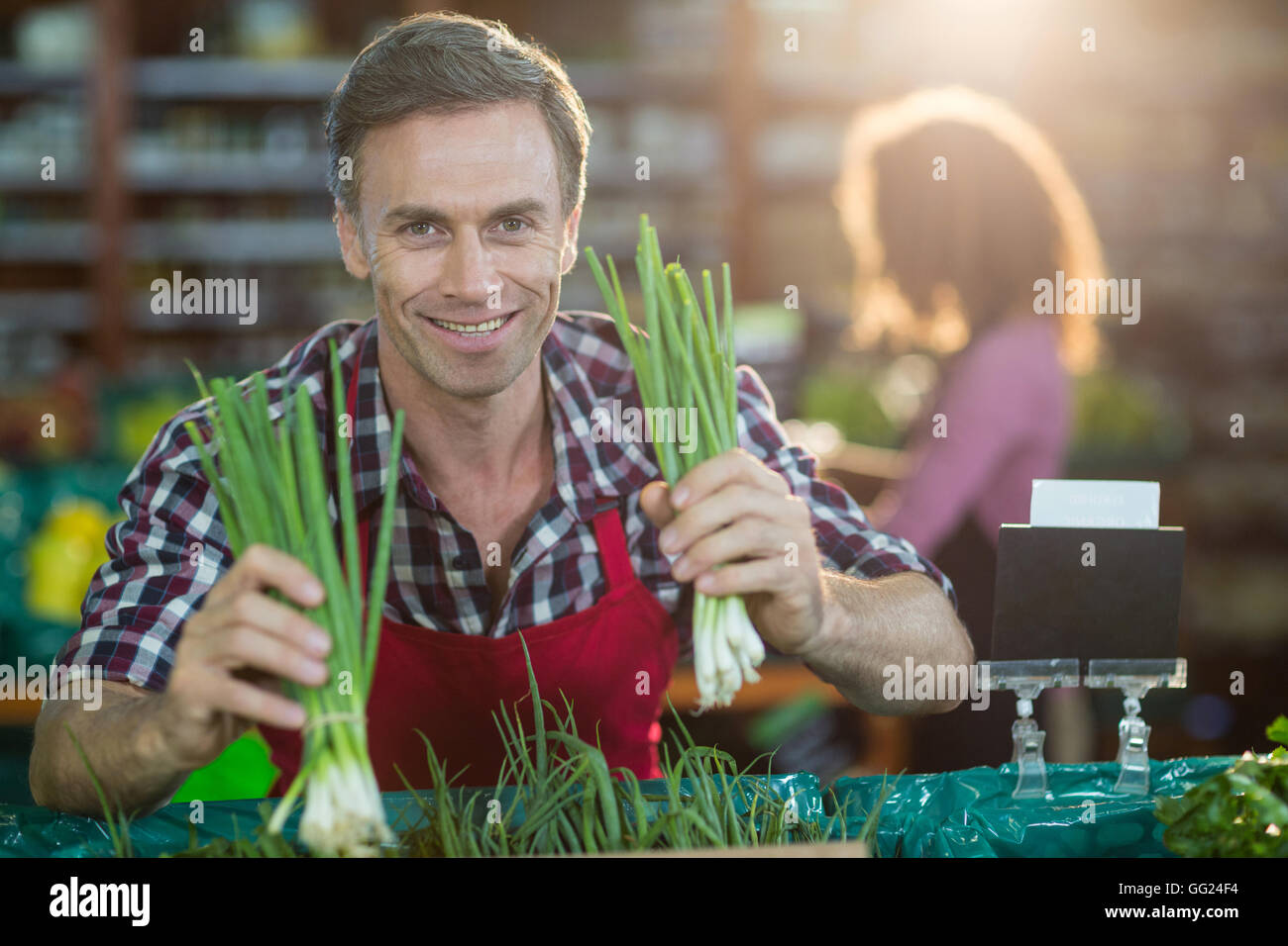 Staff arranging vegetables in organic section Stock Photo - Alamy