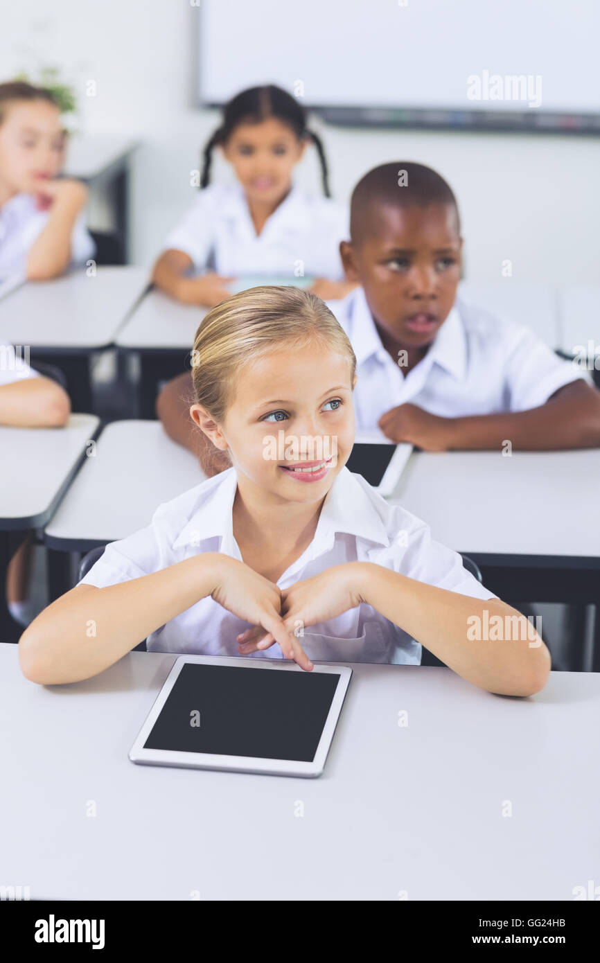 Smiling schoolgirl using digital tablet in classroom Stock Photo - Alamy