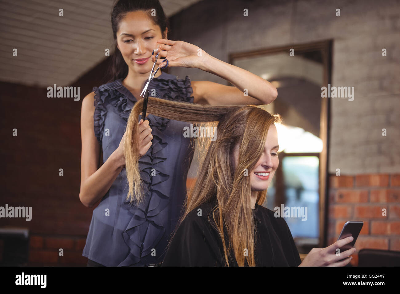 Female getting her hair trimmed Stock Photo - Alamy