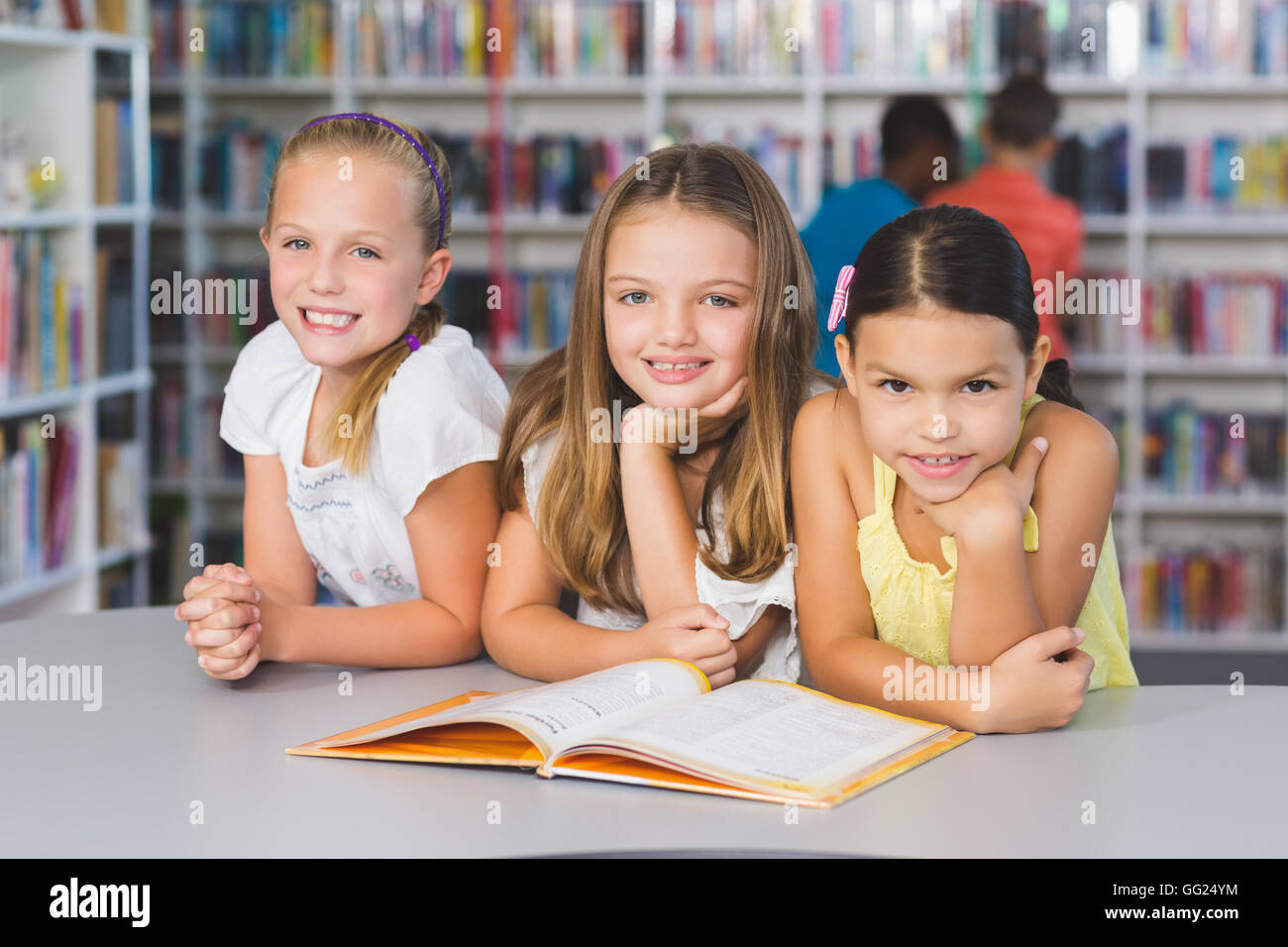 School kids reading book together in library Stock Photo - Alamy