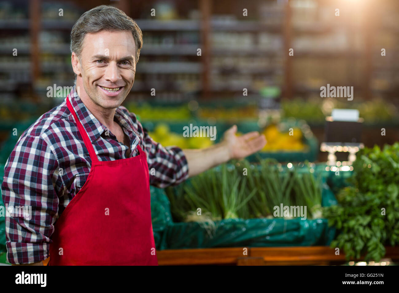 Smiling male staff showing organic section Stock Photo - Alamy
