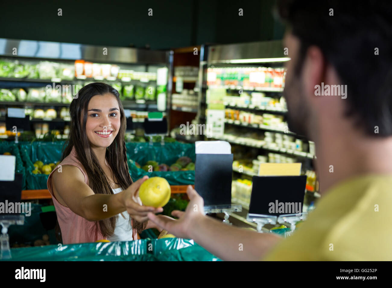 Woman giving fruit to cashier for billing at supermarket Stock Photo ...