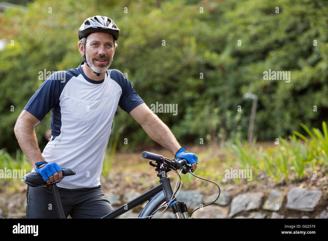 Man standing with mountain bike on the road Stock Photo - Alamy