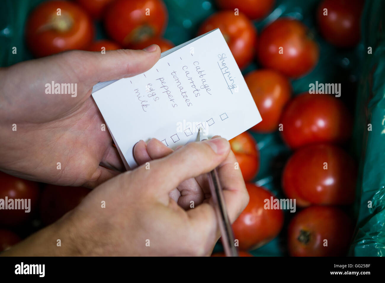 Man ticking on shopping checklist Stock Photo - Alamy
