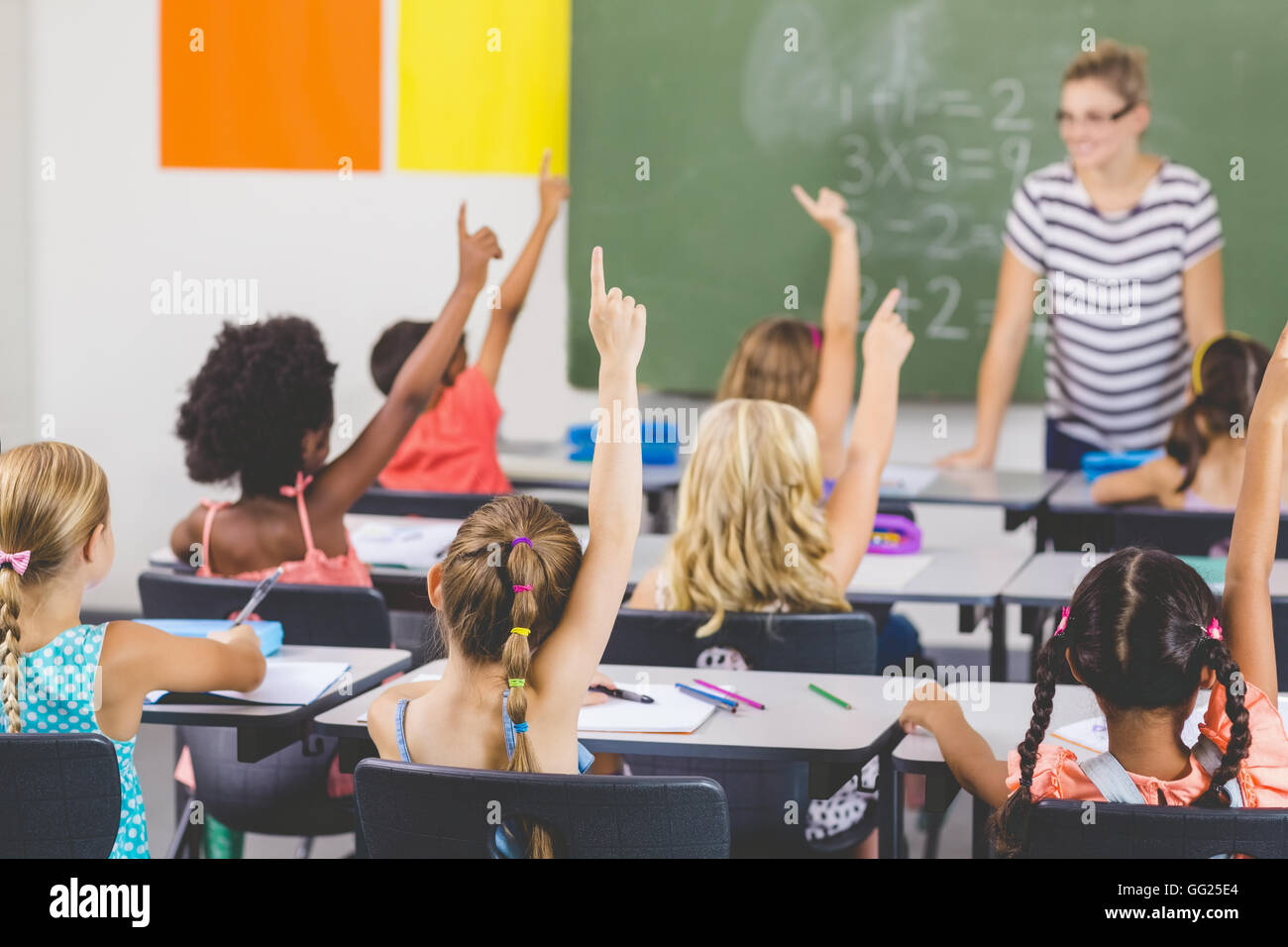School kids raising hand in classroom Stock Photo - Alamy