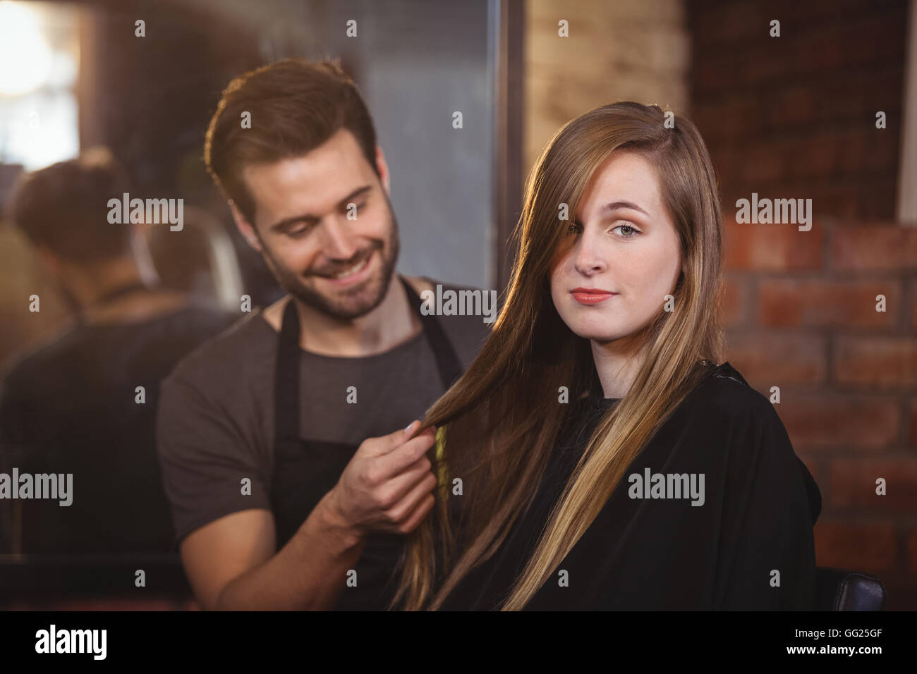 Handsome hair stylist with client Stock Photo - Alamy